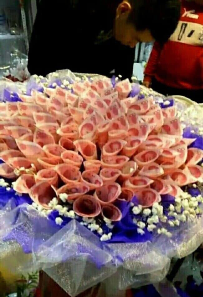 Il offre un bouquet de billets de banque d'une valeur de 1400€